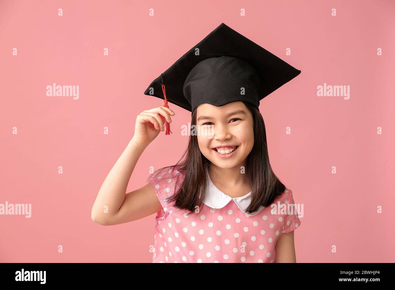 Little girl in graduation hat on color background Stock Photo - Alamy