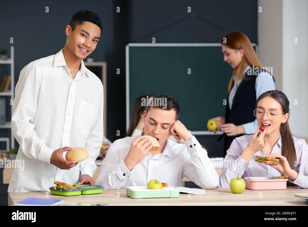 Pupils having lunch in classroom Stock Photo - Alamy