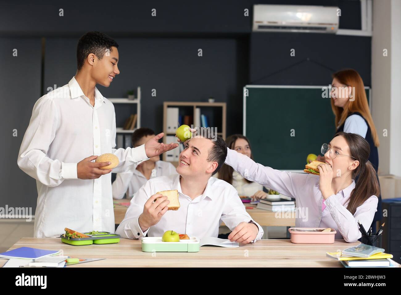 Pupils having lunch in classroom Stock Photo - Alamy