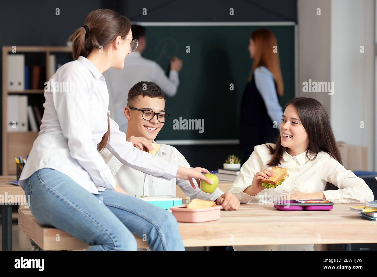 Pupils having lunch in classroom Stock Photo - Alamy