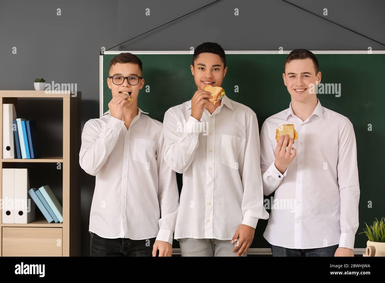 Pupils having lunch in classroom Stock Photo - Alamy