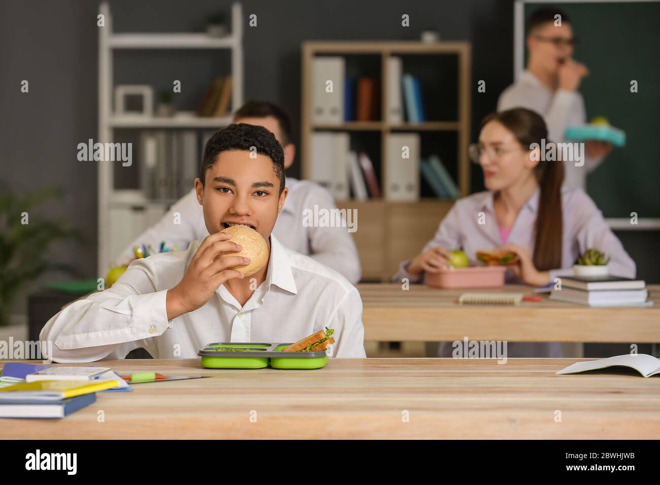 Pupils having lunch in classroom Stock Photo - Alamy