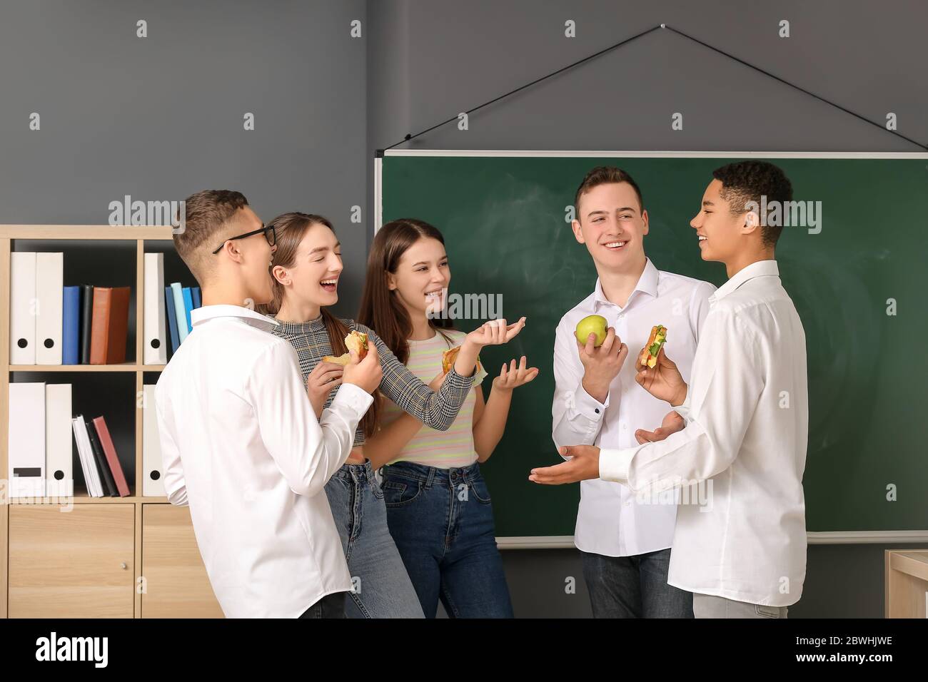 Pupils having lunch in classroom Stock Photo - Alamy