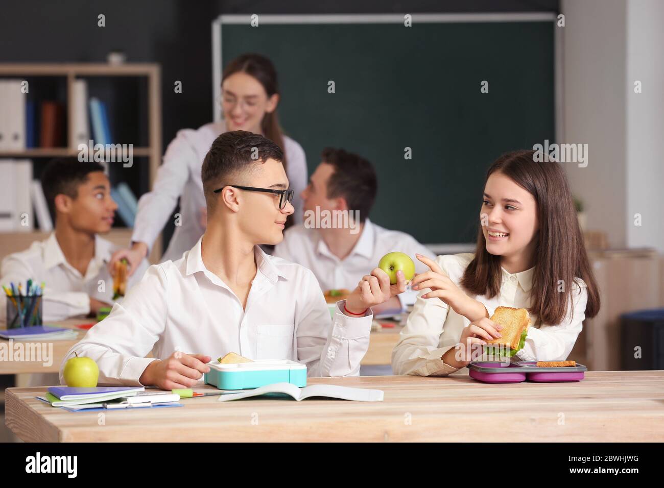 Pupils having lunch in classroom Stock Photo - Alamy