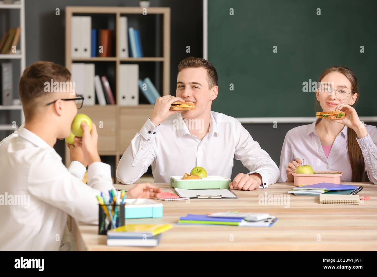 Pupils having lunch in classroom Stock Photo - Alamy