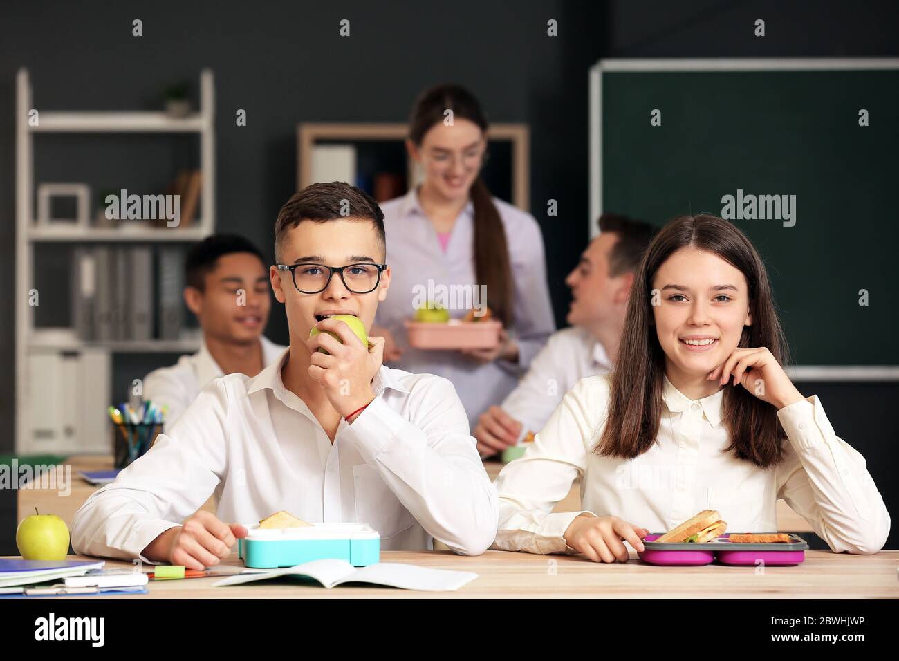 Pupils having lunch in classroom Stock Photo - Alamy