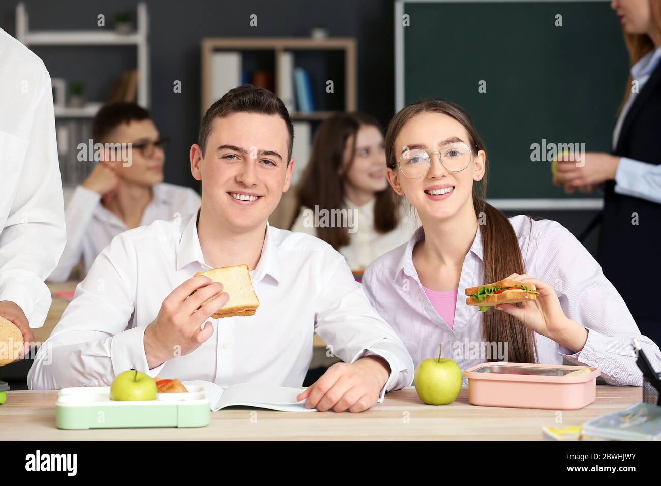 Pupils having lunch in classroom Stock Photo - Alamy