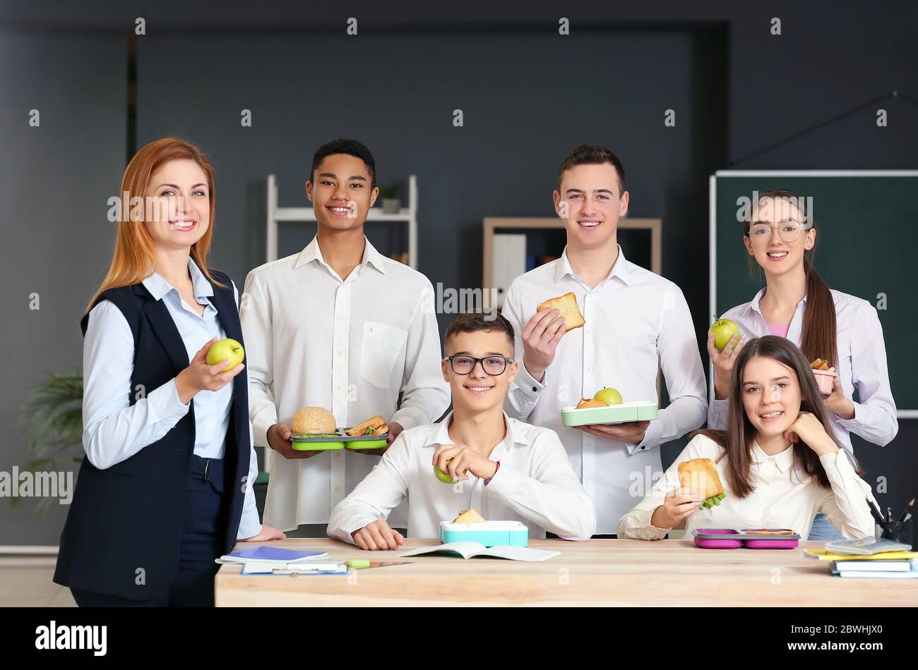 Pupils and teacher having lunch in classroom Stock Photo - Alamy
