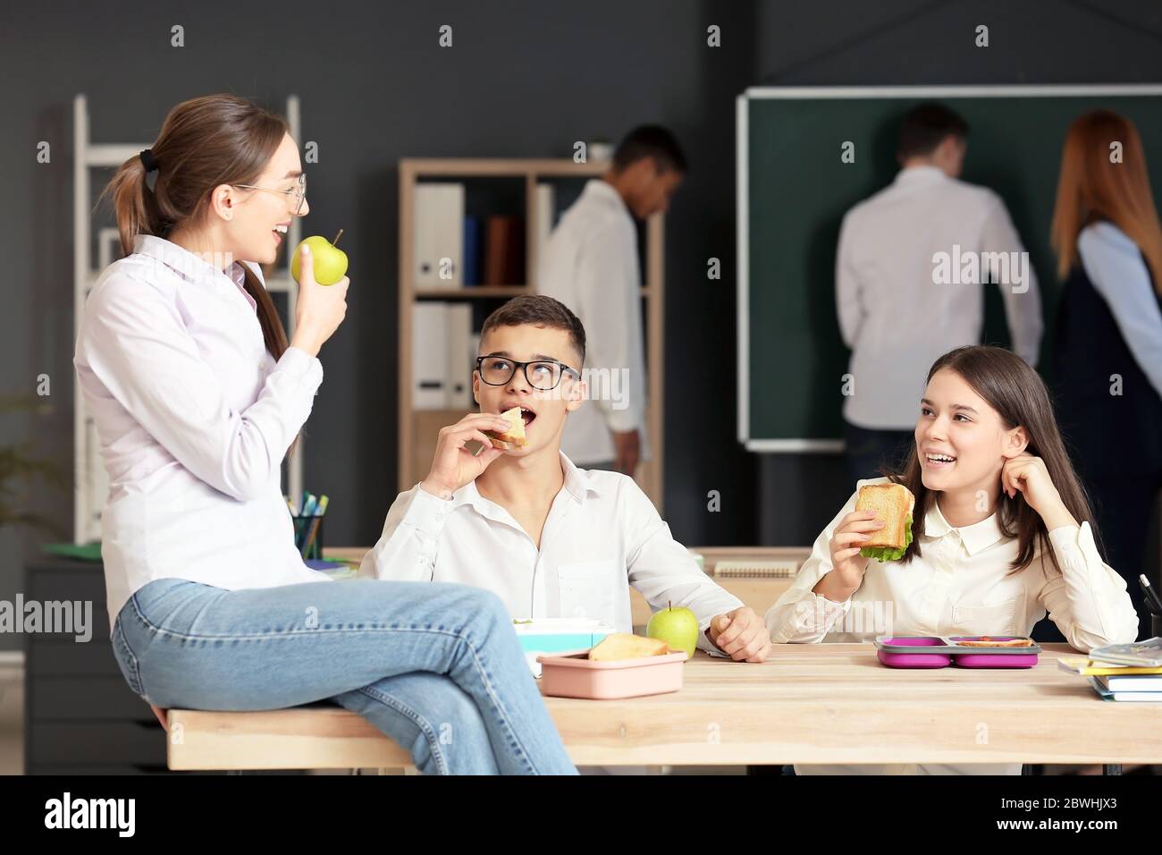 Pupils having lunch in classroom Stock Photo - Alamy