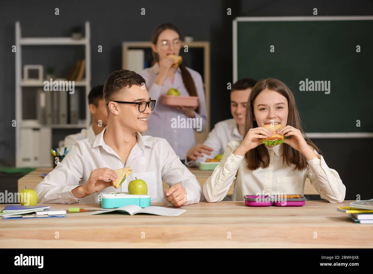 Pupils having lunch in classroom Stock Photo - Alamy