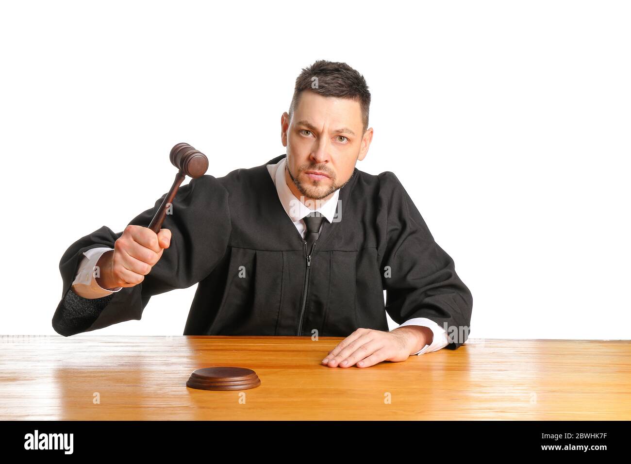 Strict male judge at table on white background Stock Photo - Alamy