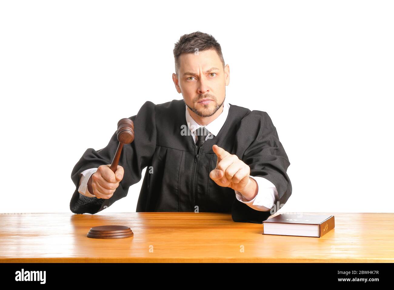 Strict male judge at table on white background Stock Photo - Alamy