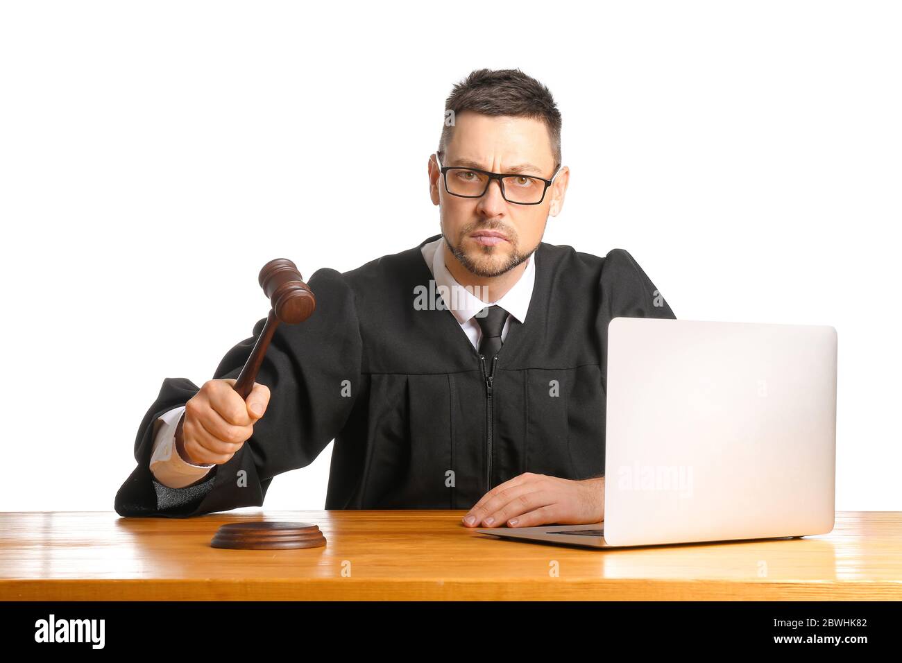 Strict male judge at table on white background Stock Photo - Alamy