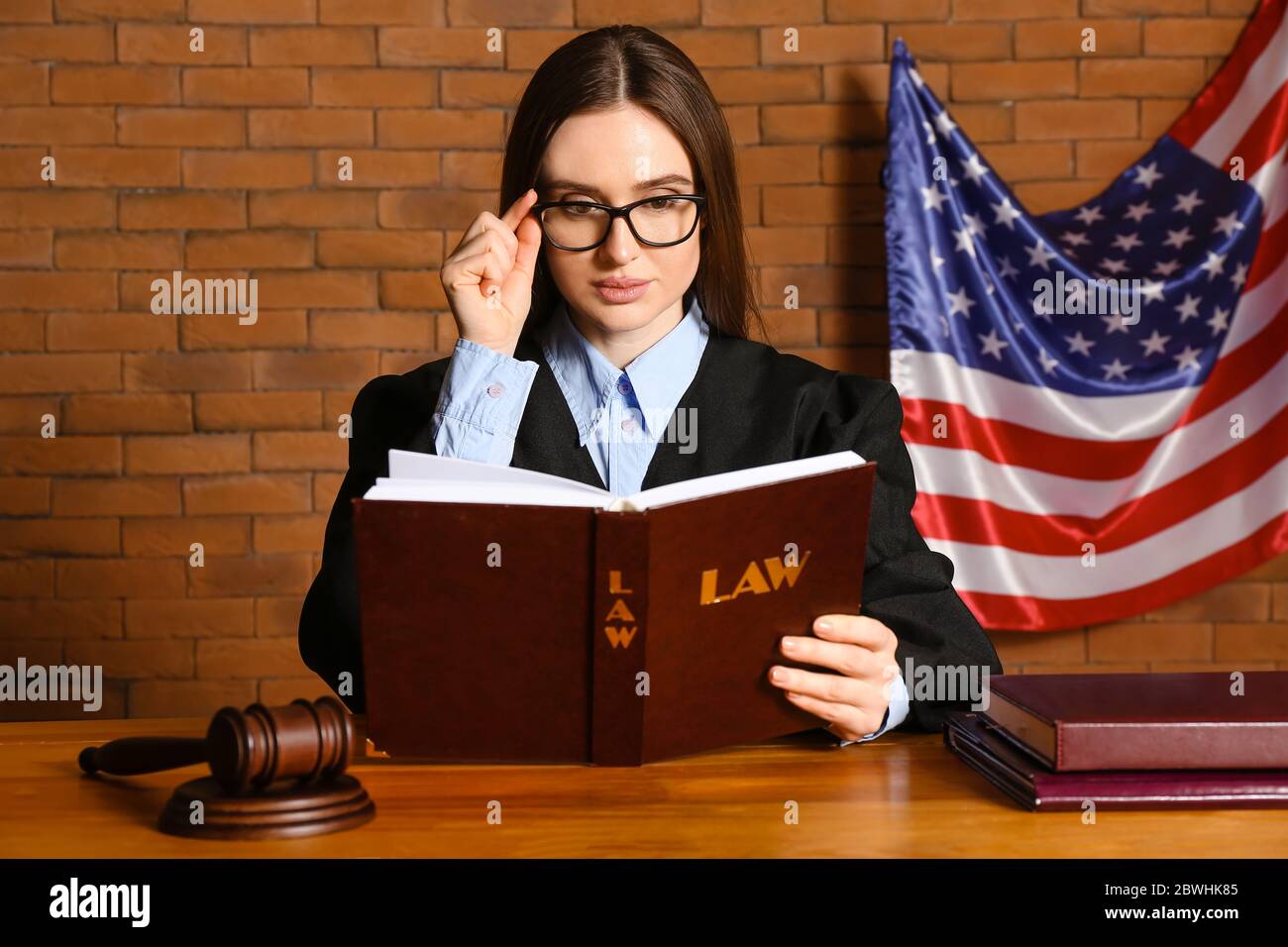 Female judge with book at table in courtroom Stock Photo - Alamy