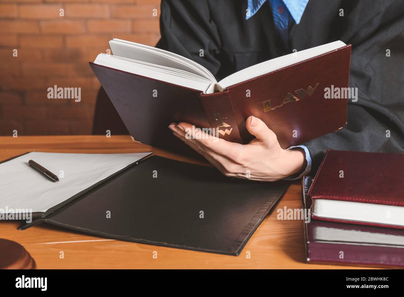 Female judge reading book at table in courtroom, closeup Stock Photo ...