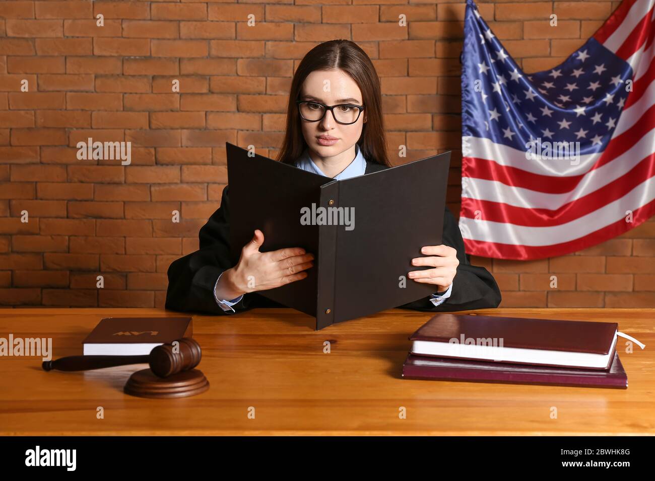 Female judge with documents at table in courtroom Stock Photo - Alamy