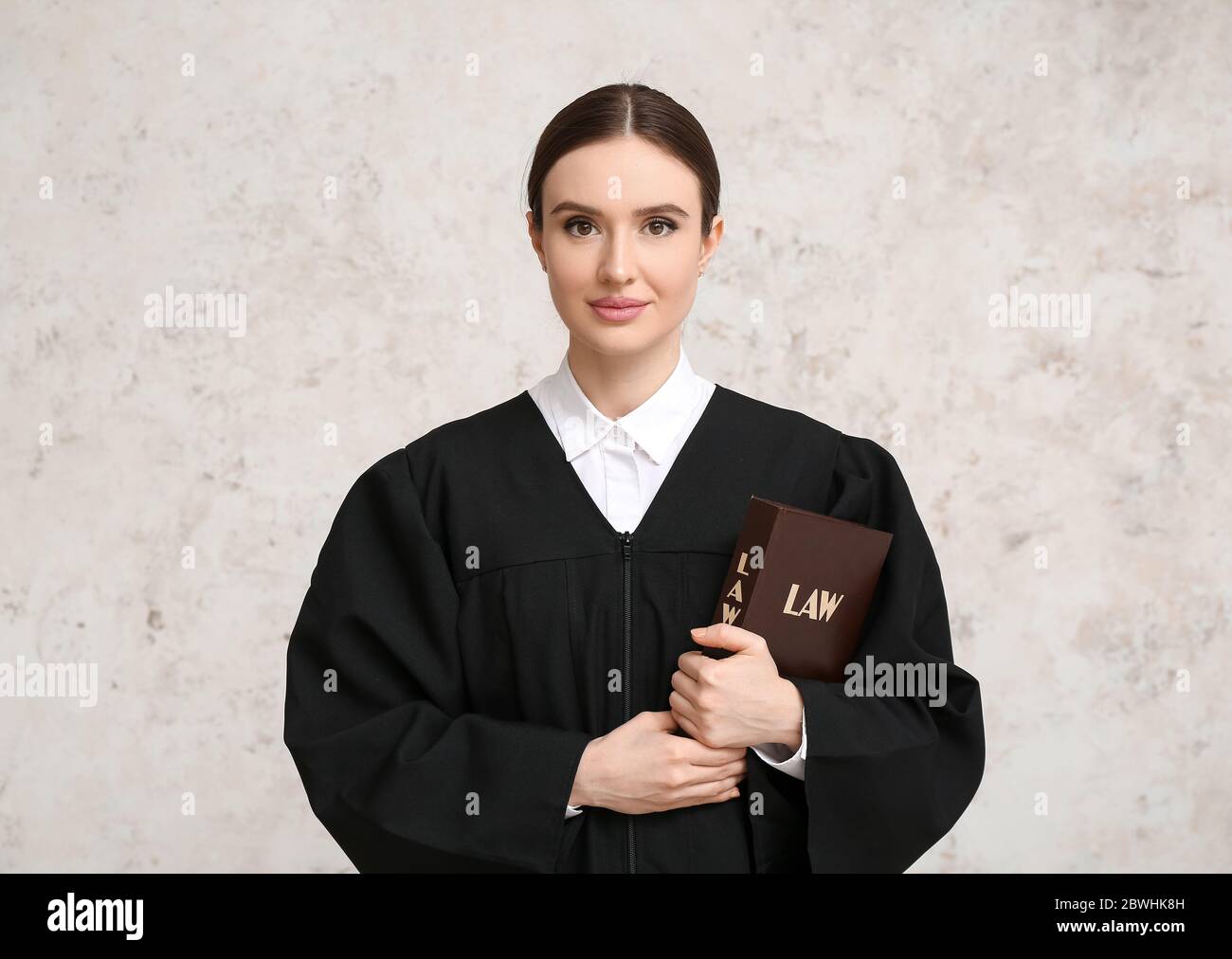 Female judge with book on light background Stock Photo - Alamy