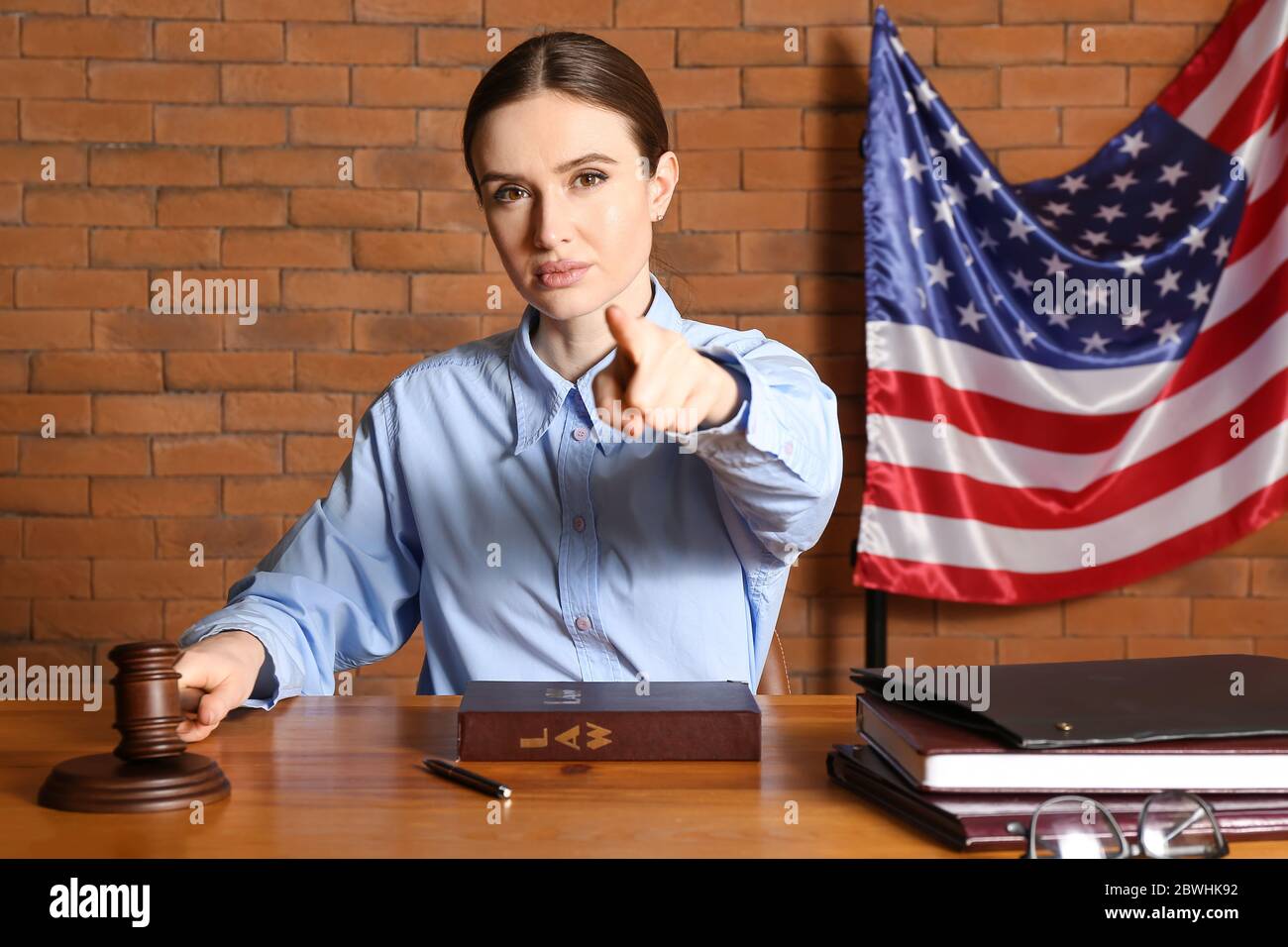 Strict female judge at table in courtroom Stock Photo - Alamy