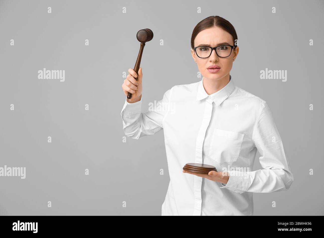 Strict female judge on light background Stock Photo - Alamy