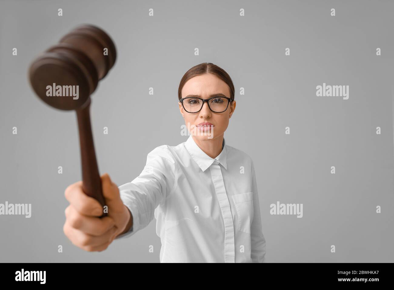 Strict female judge on light background Stock Photo - Alamy
