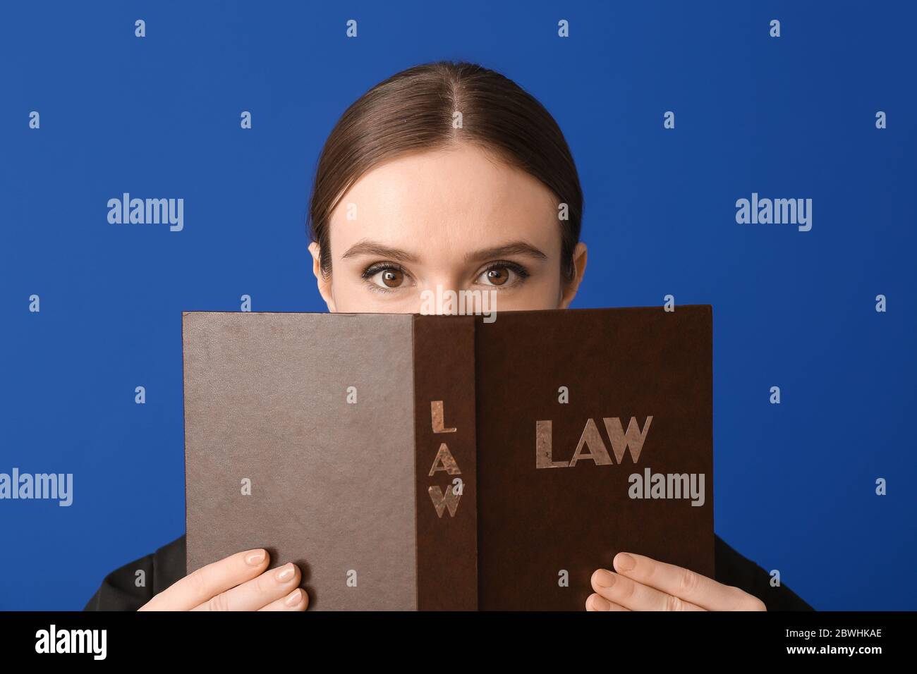 Female judge with book on color background Stock Photo - Alamy