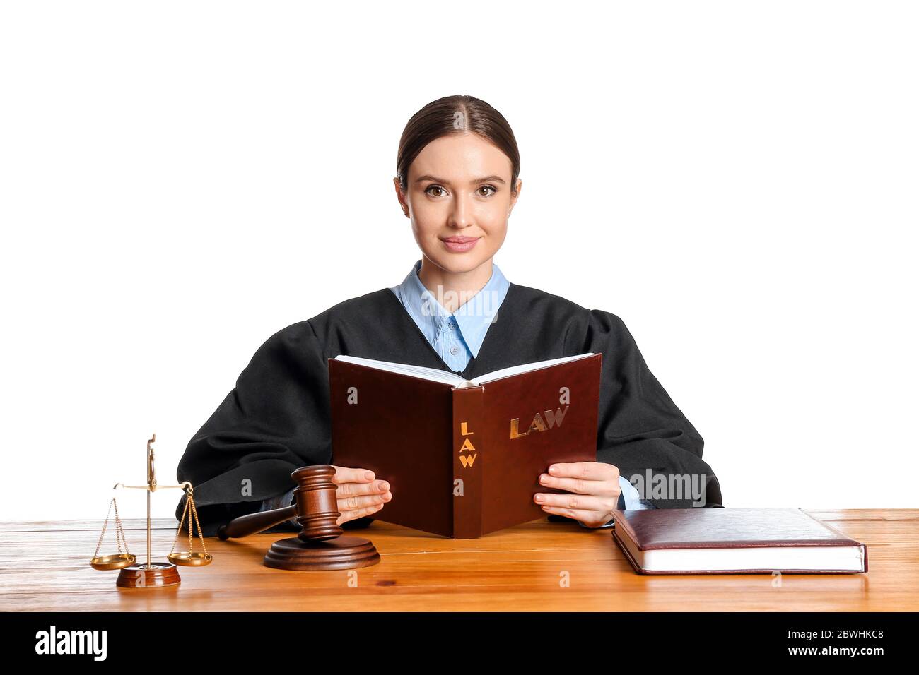 Female judge with book at table on white background Stock Photo - Alamy