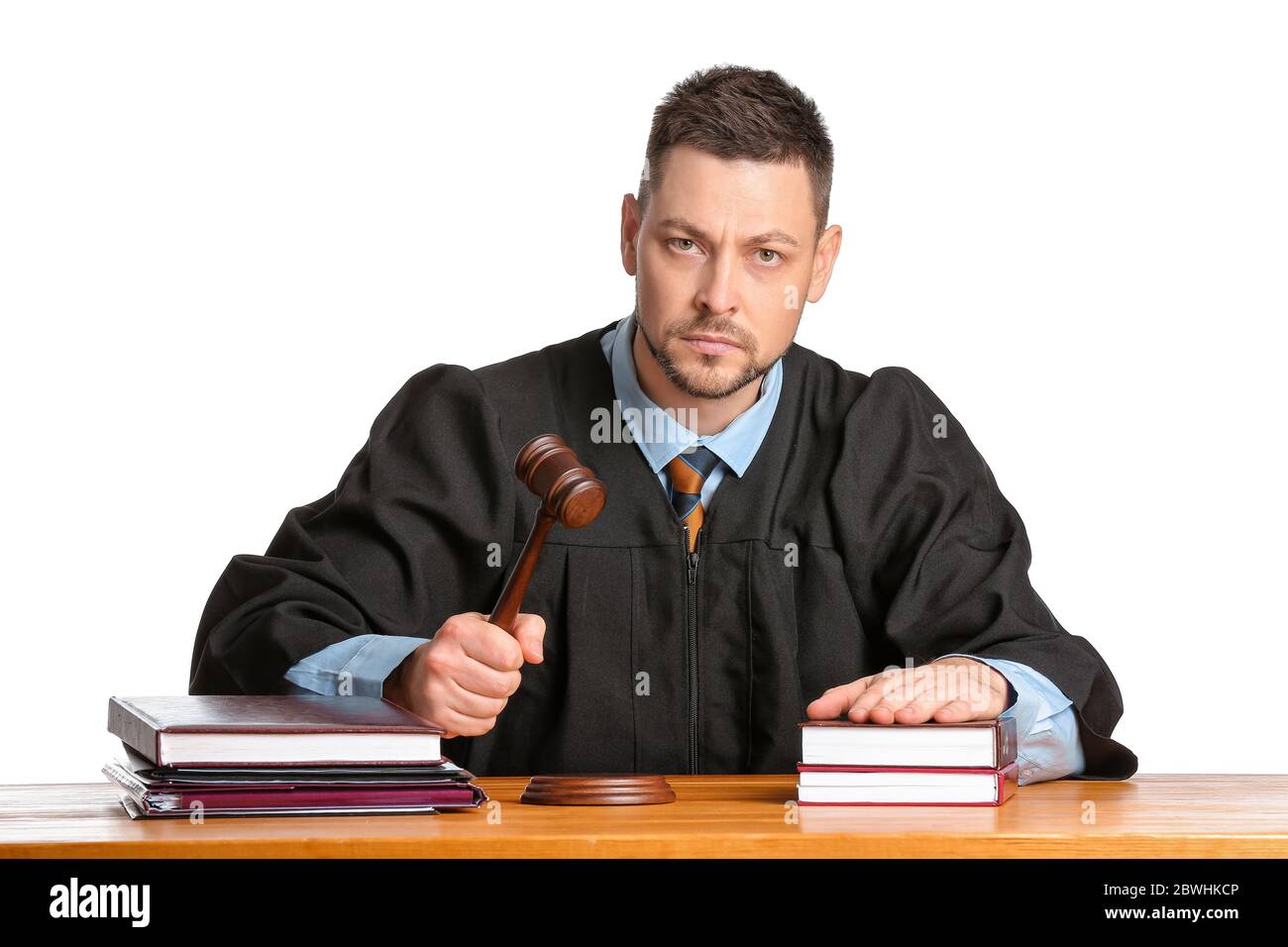Strict male judge at table on white background Stock Photo - Alamy