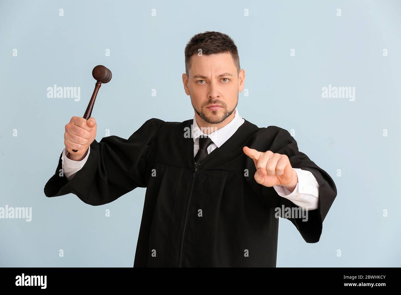 Strict male judge on light background Stock Photo - Alamy