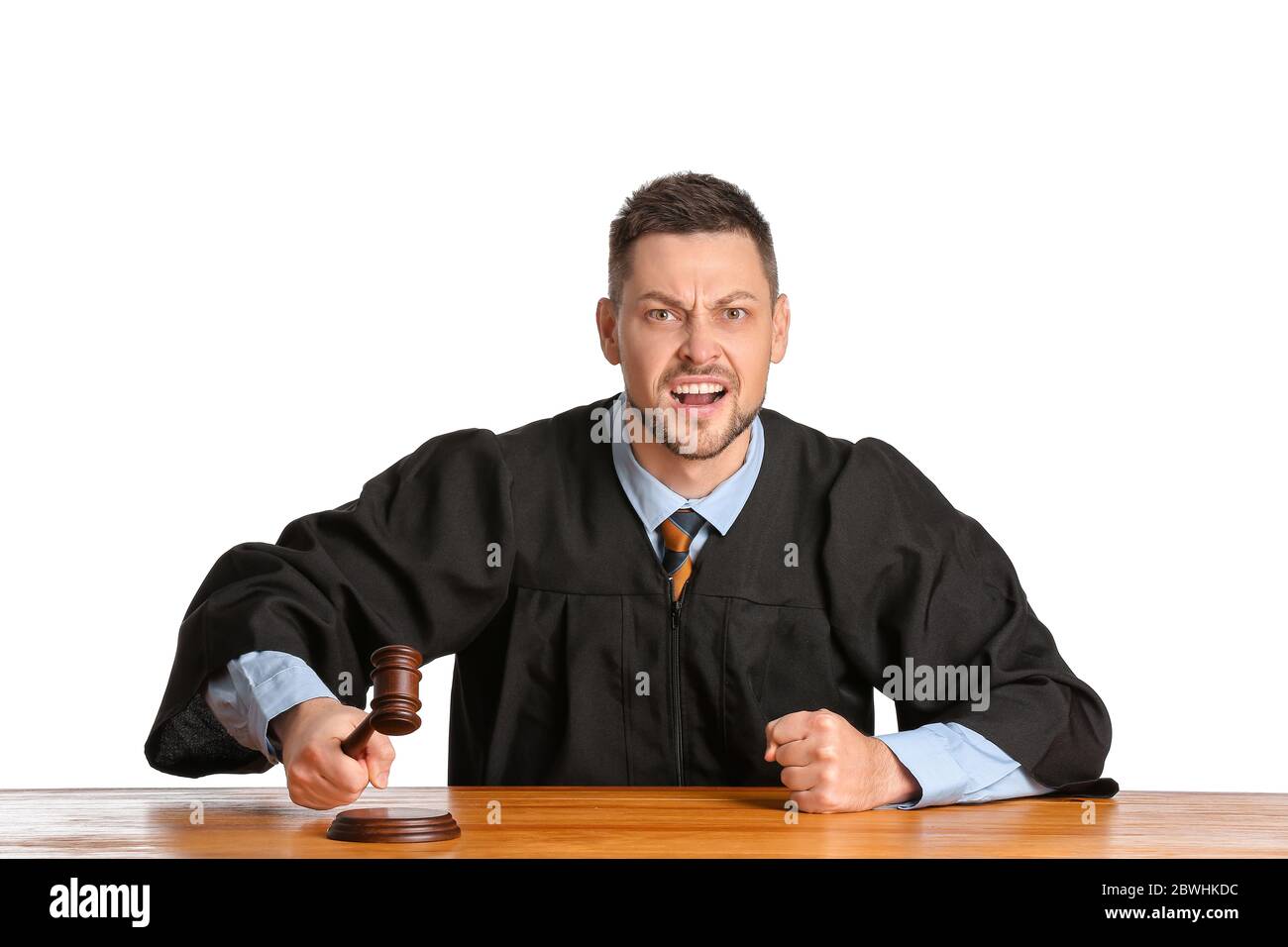 Angry male judge at table on white background Stock Photo - Alamy