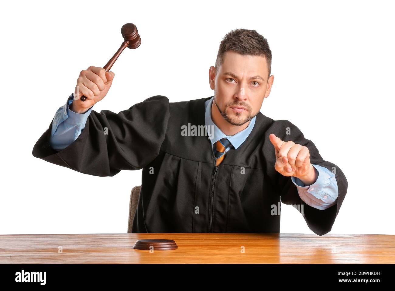 Strict male judge at table on white background Stock Photo - Alamy