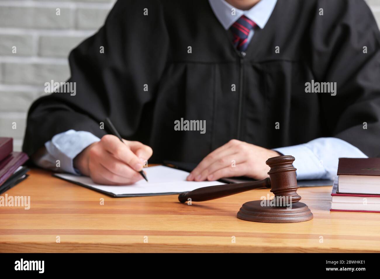 Male judge signing documents at table in courtroom Stock Photo - Alamy