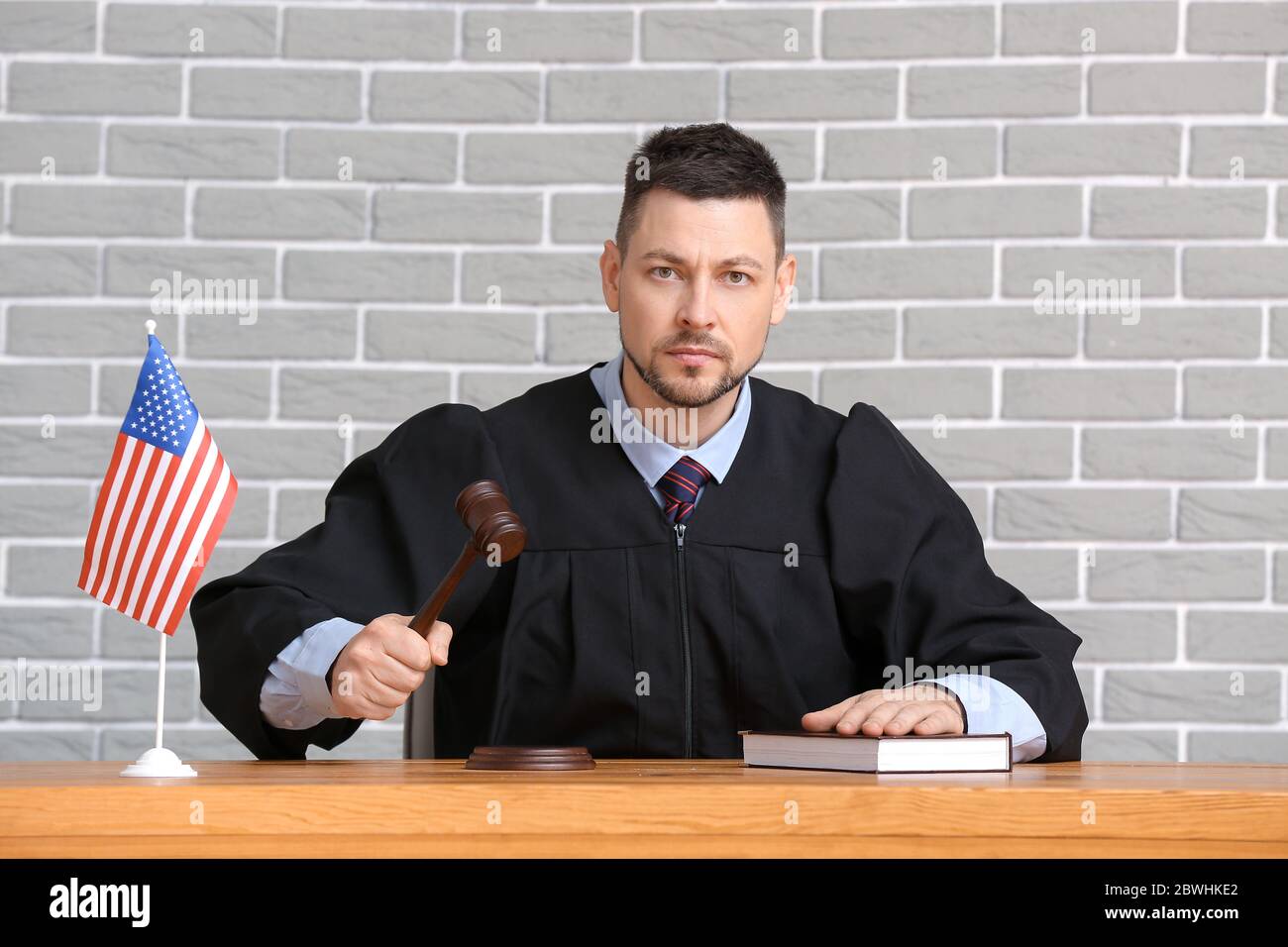 Strict male judge at table in courtroom Stock Photo - Alamy