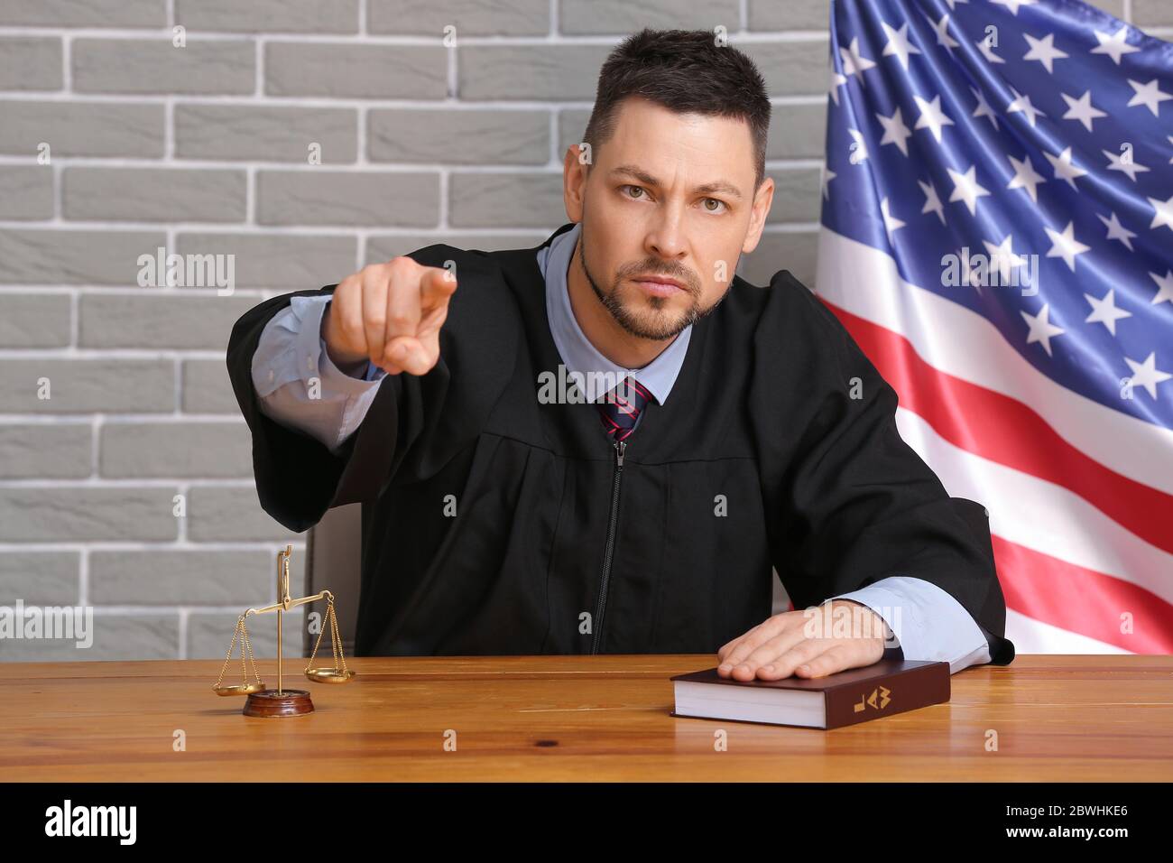 Strict male judge at table in courtroom Stock Photo - Alamy
