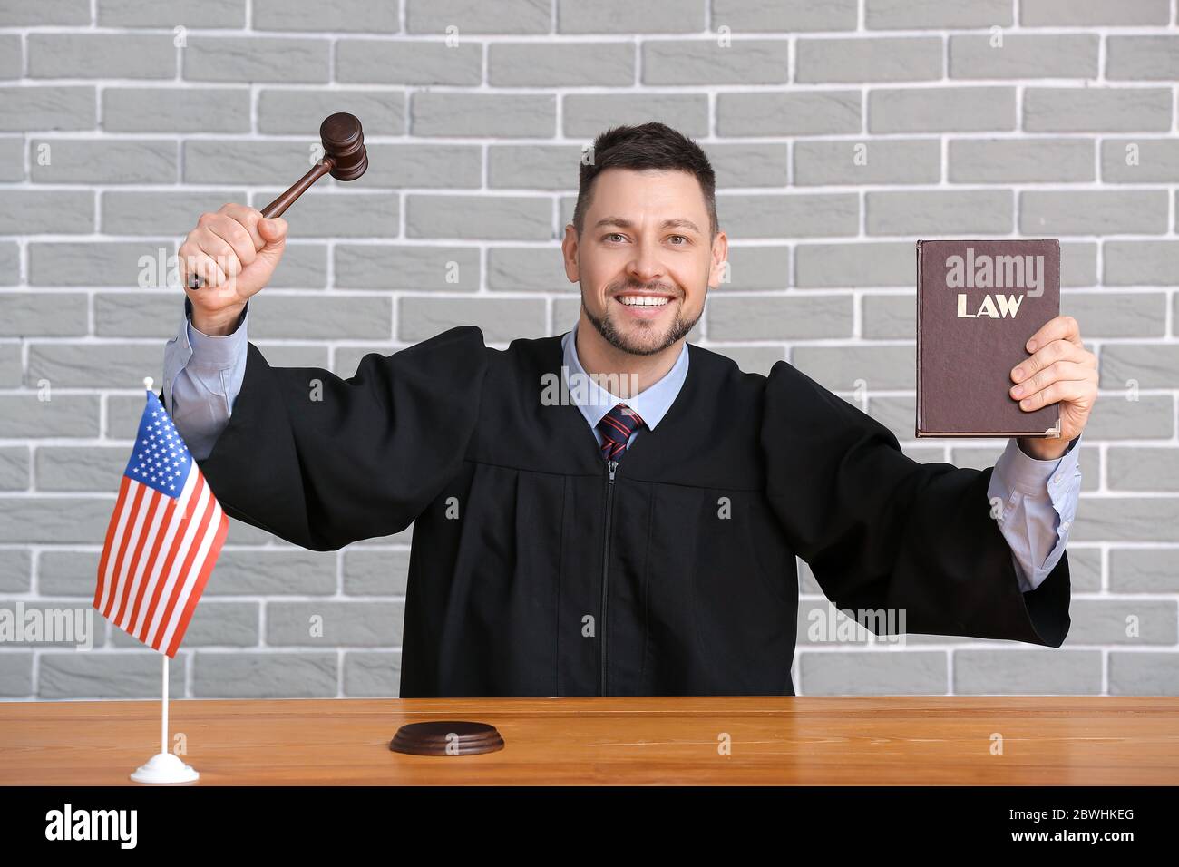 Happy male judge at table in courtroom Stock Photo - Alamy