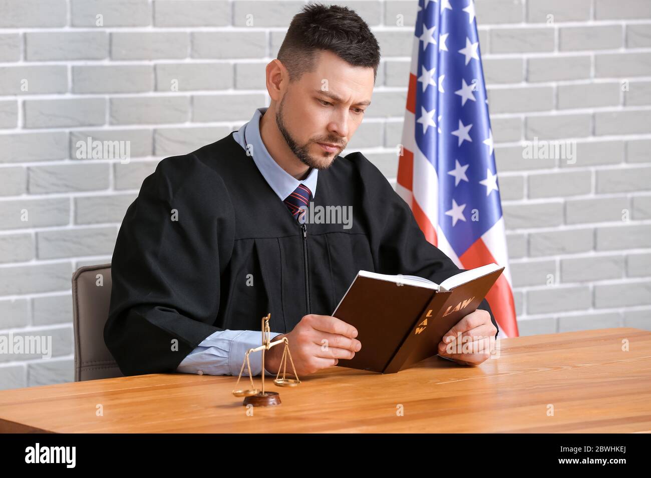 Male judge with book at table in courtroom Stock Photo - Alamy