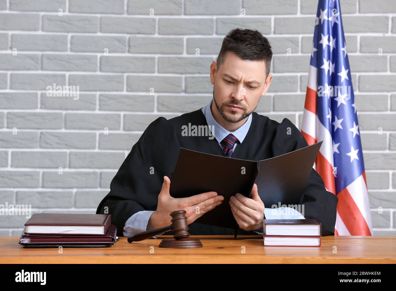 Male judge with documents at table in courtroom Stock Photo - Alamy