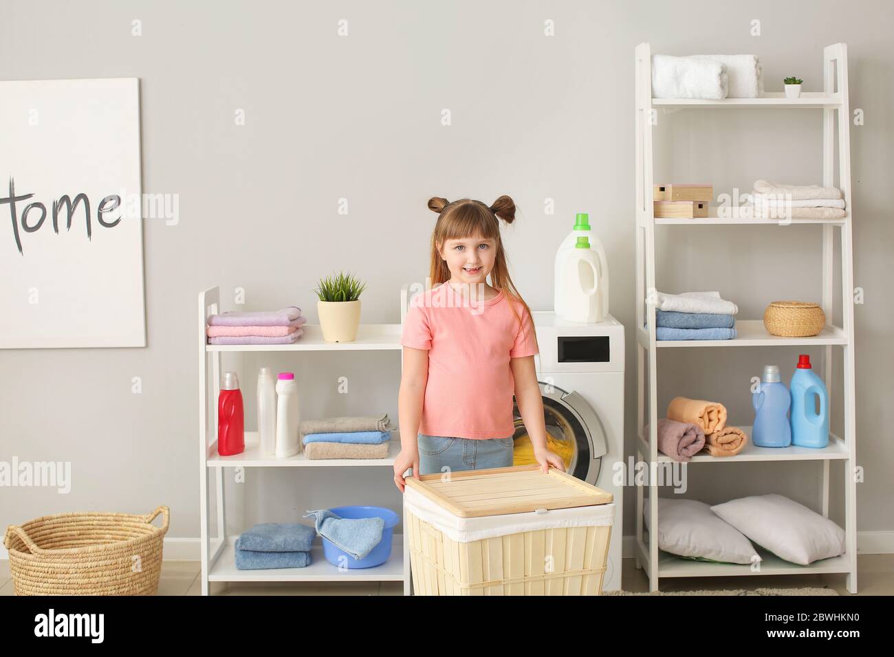 Cute little girl doing laundry at home Stock Photo - Alamy