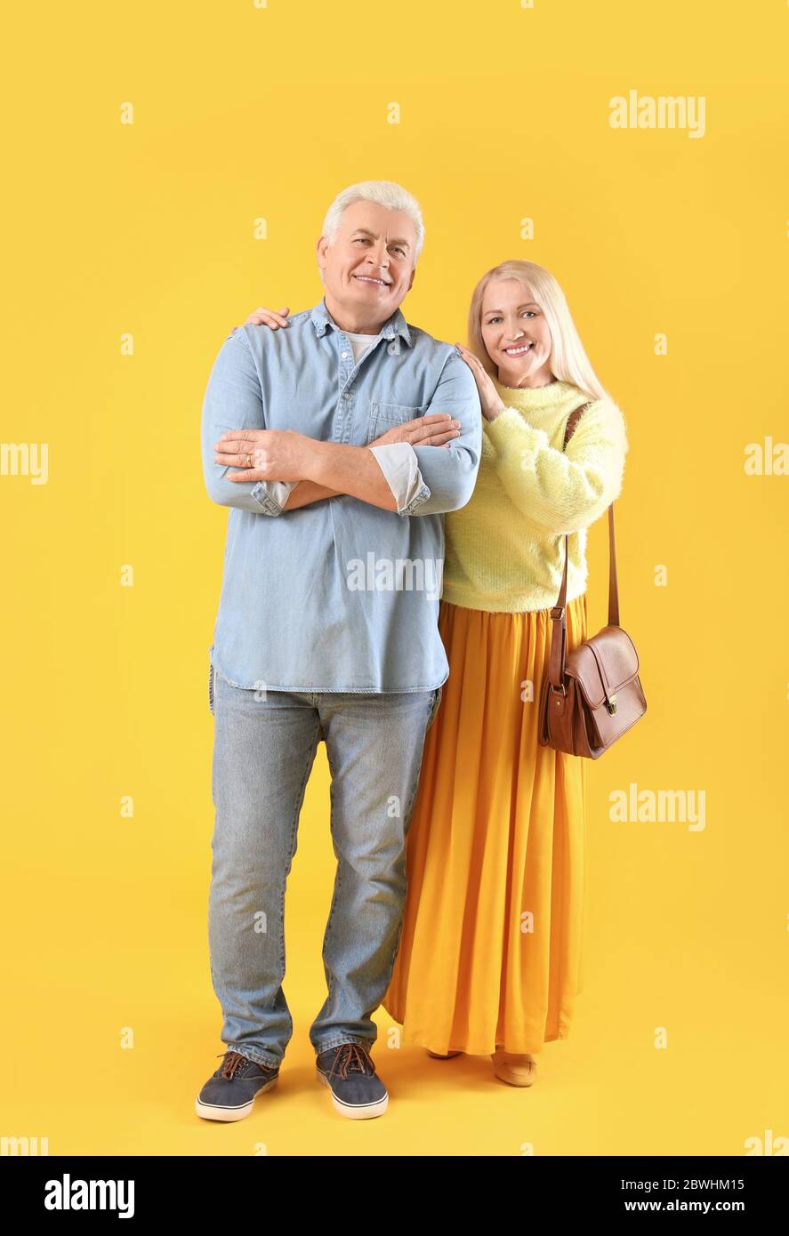 Portrait of happy elderly couple on color background Stock Photo - Alamy
