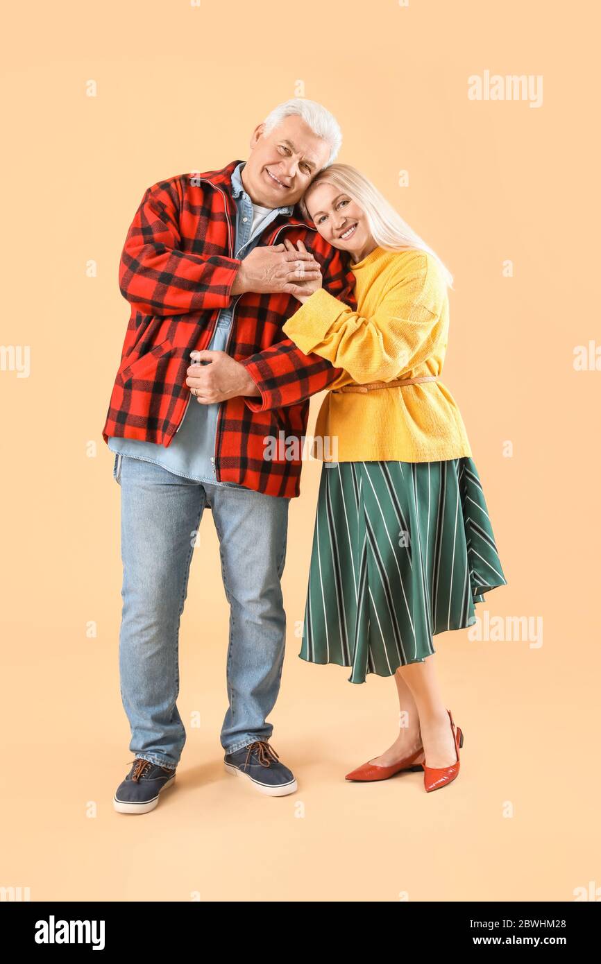 Portrait of happy elderly couple on color background Stock Photo - Alamy