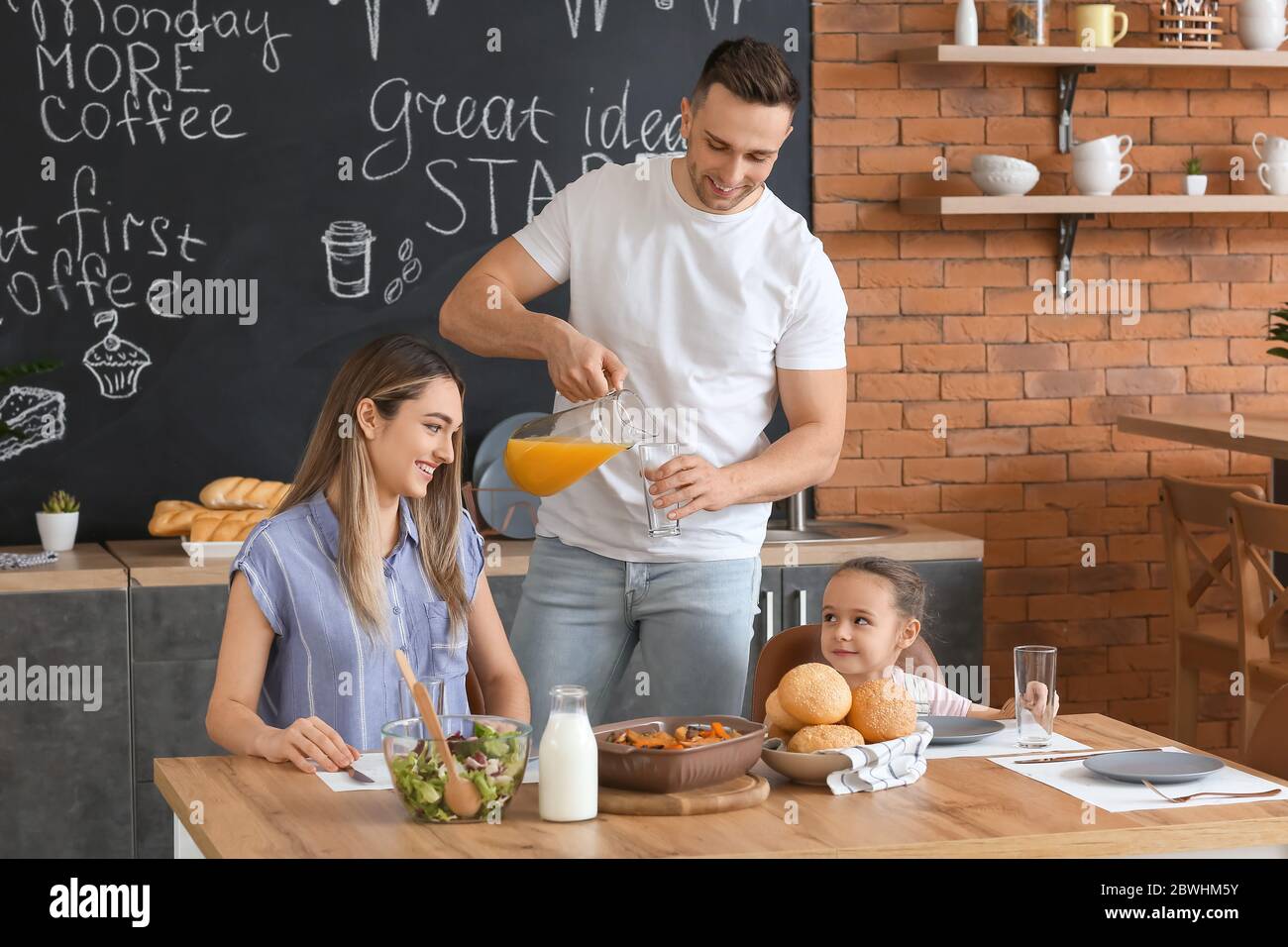 Happy family having dinner together in kitchen Stock Photo - Alamy