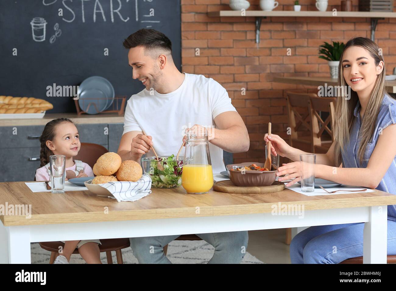 Happy family having dinner together in kitchen Stock Photo - Alamy