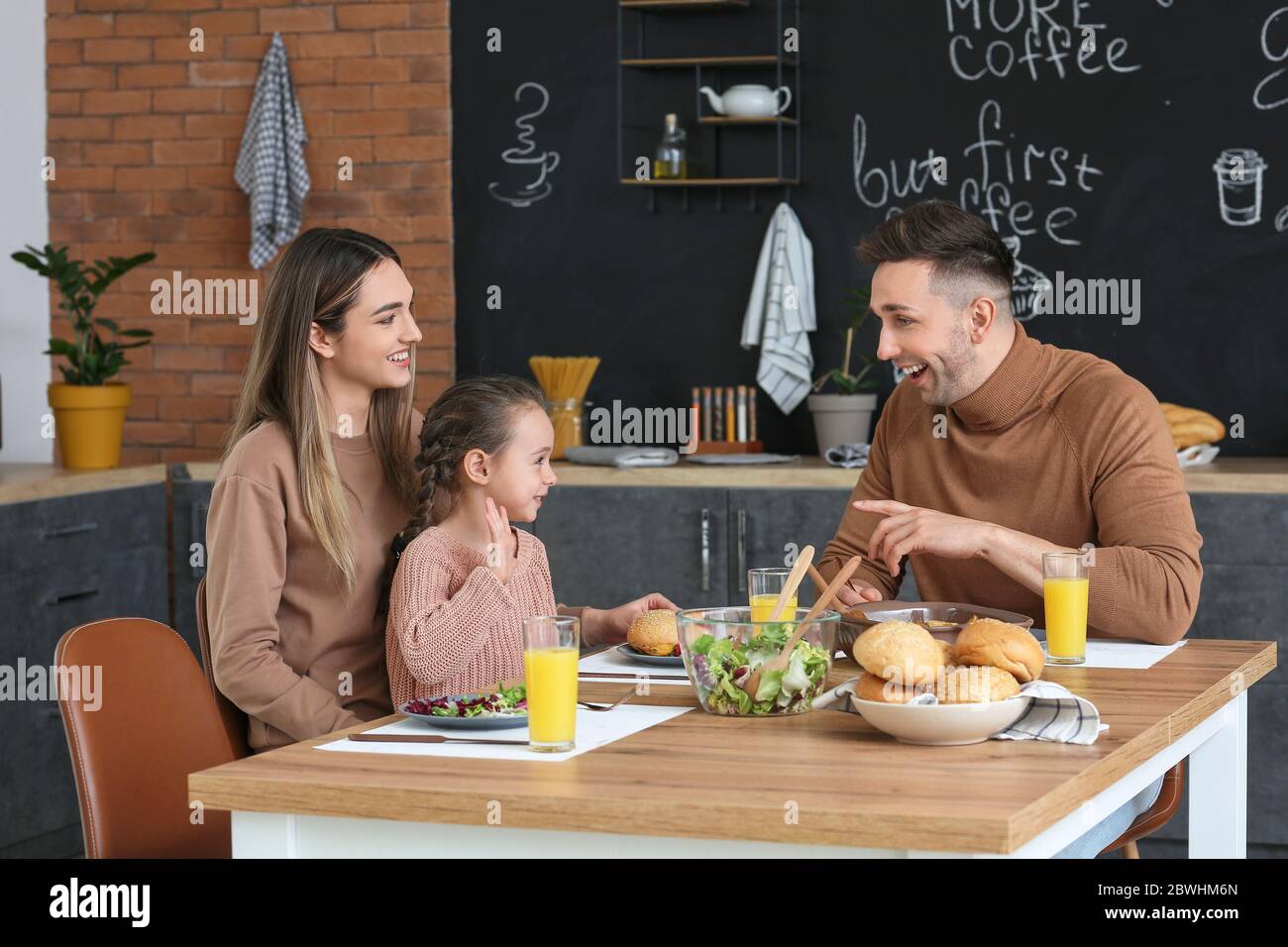 Happy family having dinner together in kitchen Stock Photo - Alamy