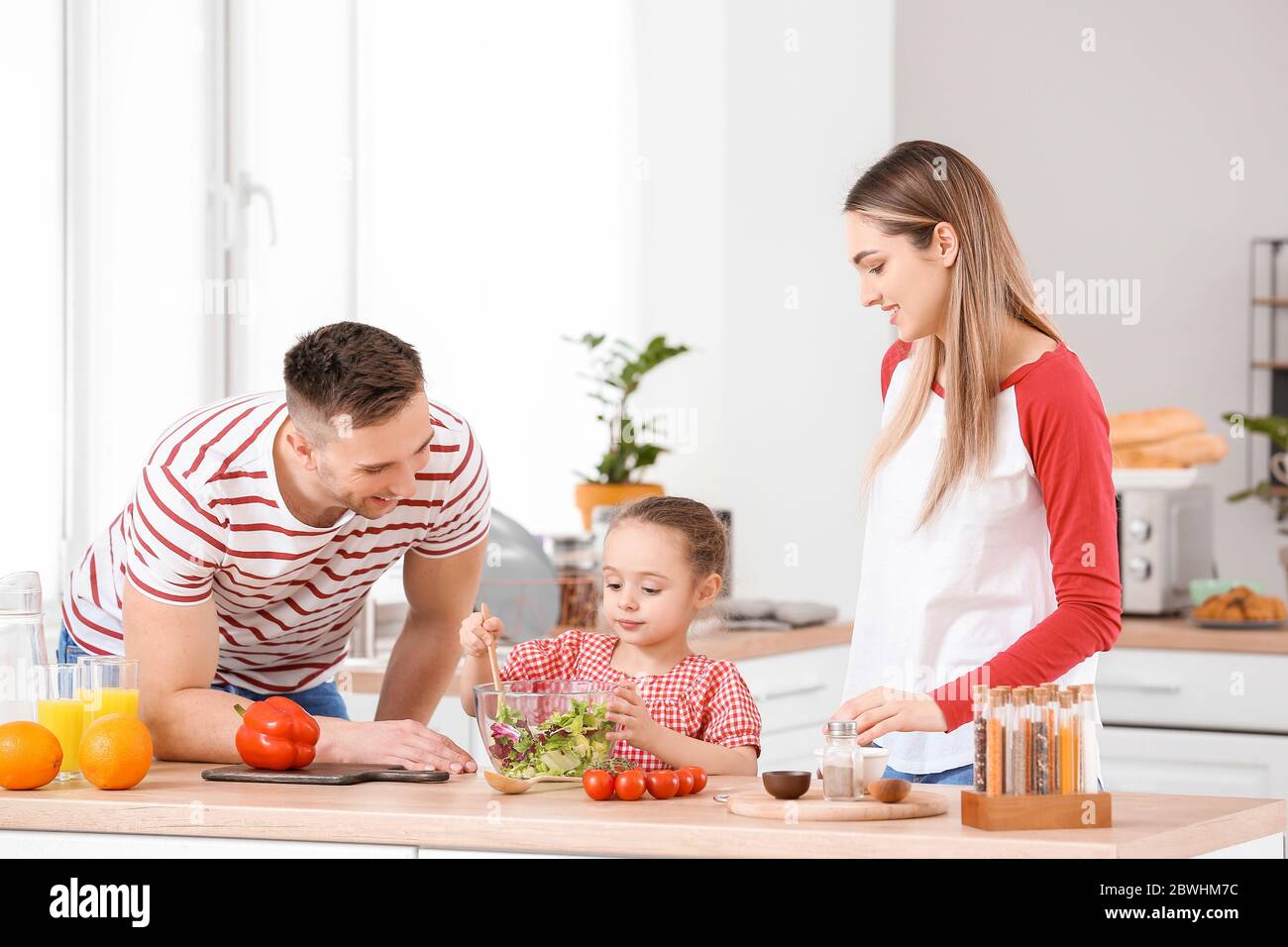 Happy family cooking together in kitchen Stock Photo - Alamy
