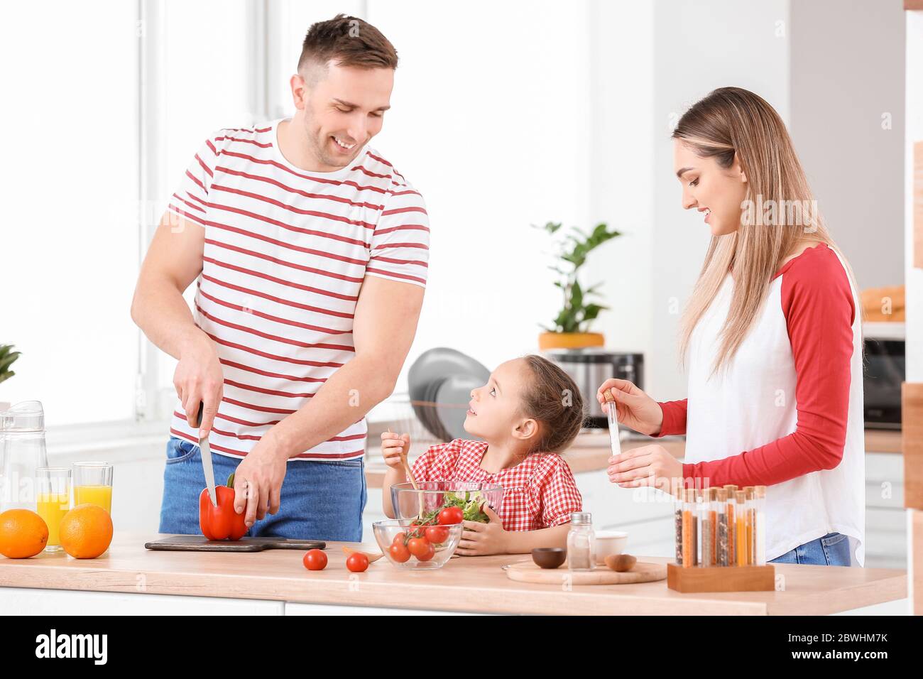 Happy family cooking together in kitchen Stock Photo - Alamy