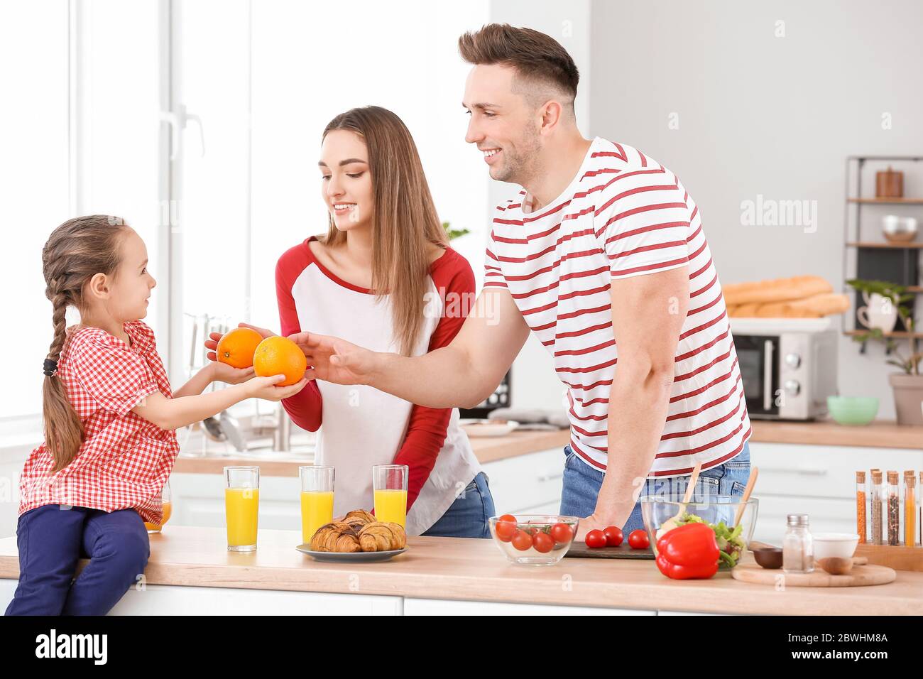 Happy family cooking together in kitchen Stock Photo - Alamy