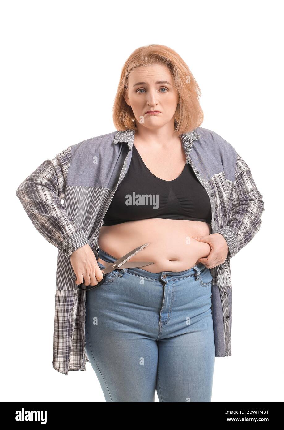 Sad overweight woman with scissors on white background. Weight loss ...