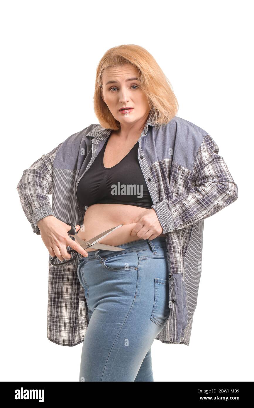 Sad overweight woman with scissors on white background. Weight loss ...
