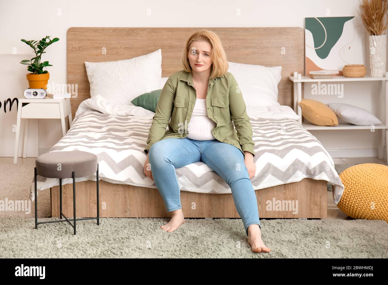 Sad overweight woman in tight clothes at home Stock Photo - Alamy