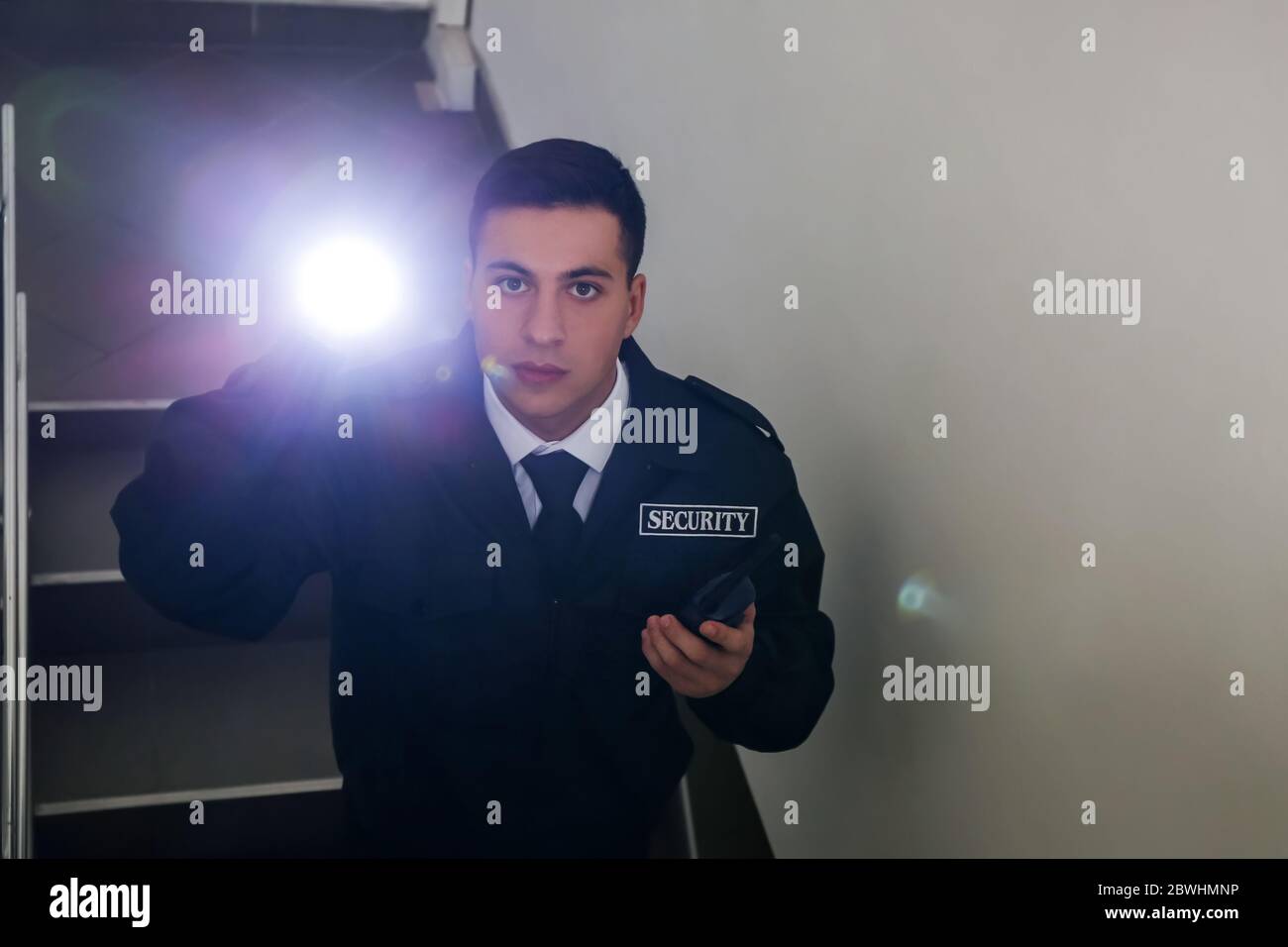 Male security guard with flashlight in building Stock Photo - Alamy