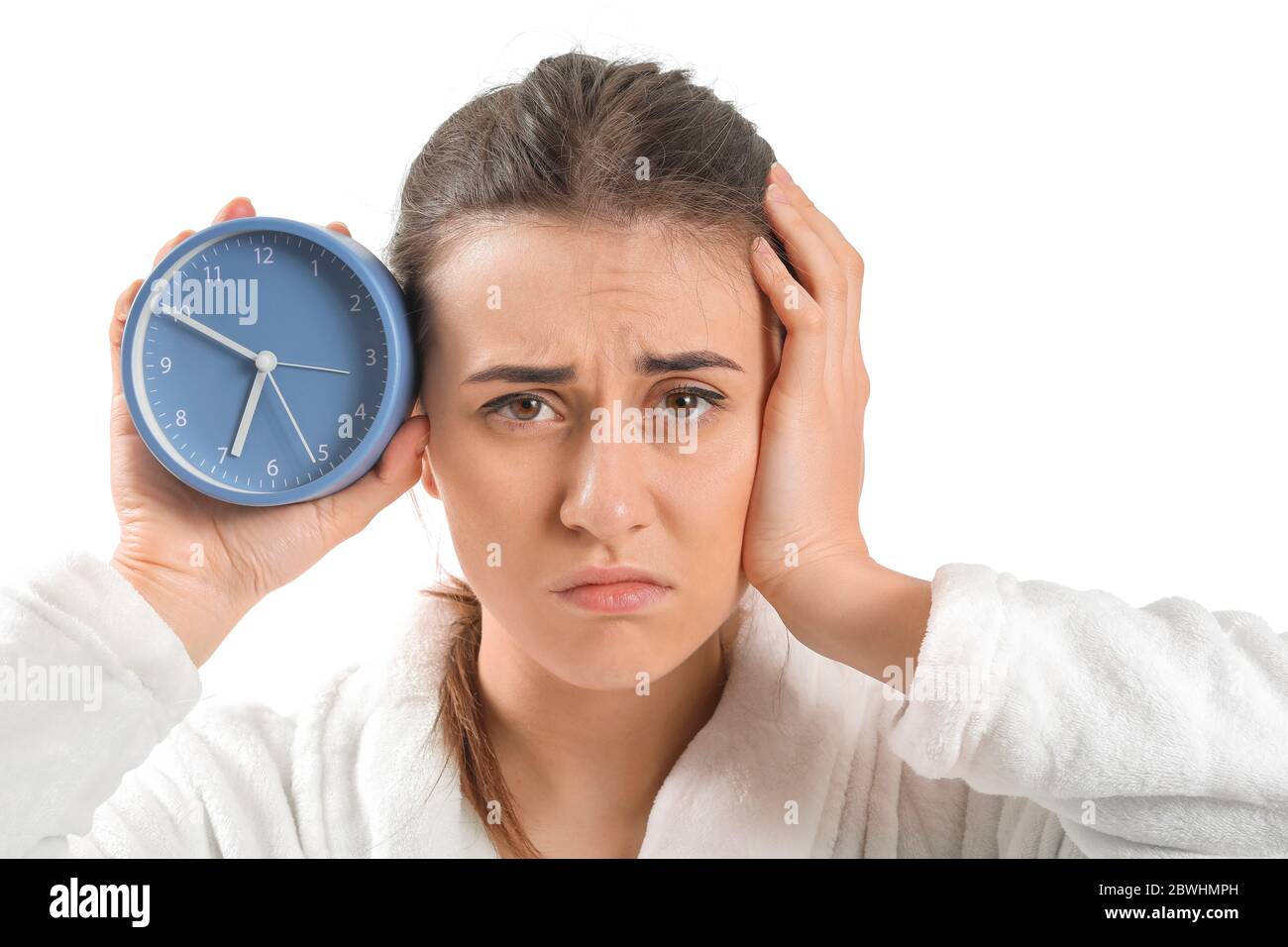 Tired young woman with alarm clock on white background Stock Photo - Alamy
